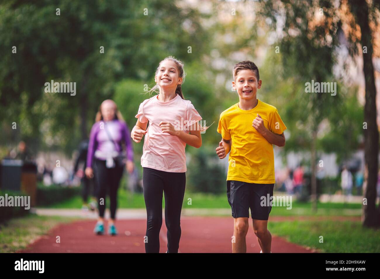 Sports and fitness in adolescence. Caucasian twins boy and girl run on ...
