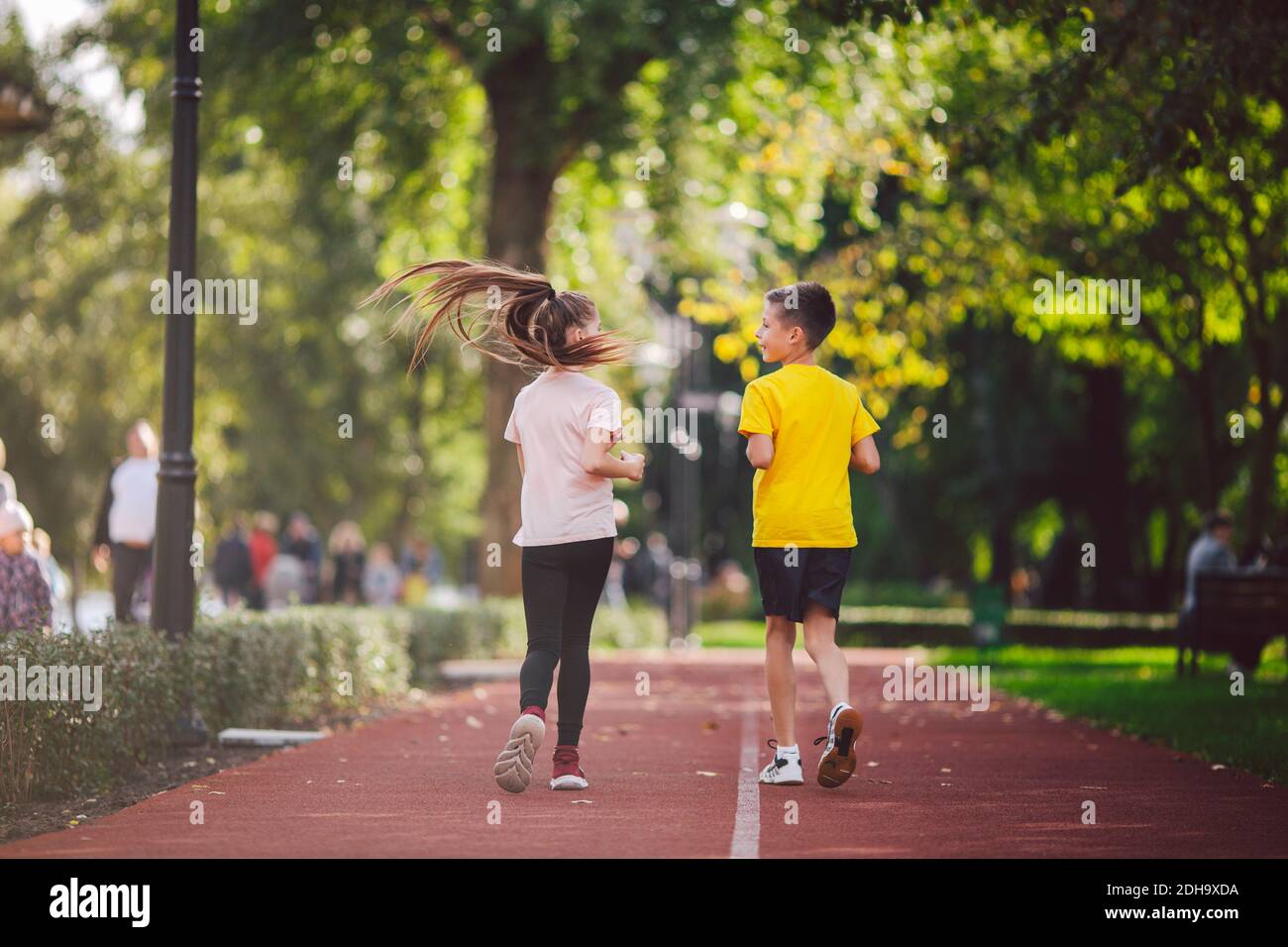 Couple of kids boy and girl doing cardio workout, jogging in park on ...