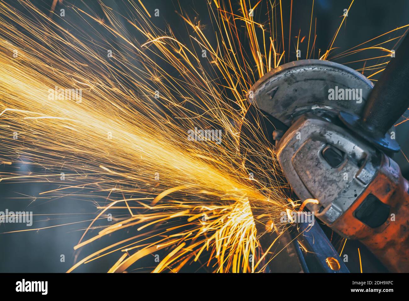 Using angle grinder, cutting metal, a lot of flashing sparks are flying ...
