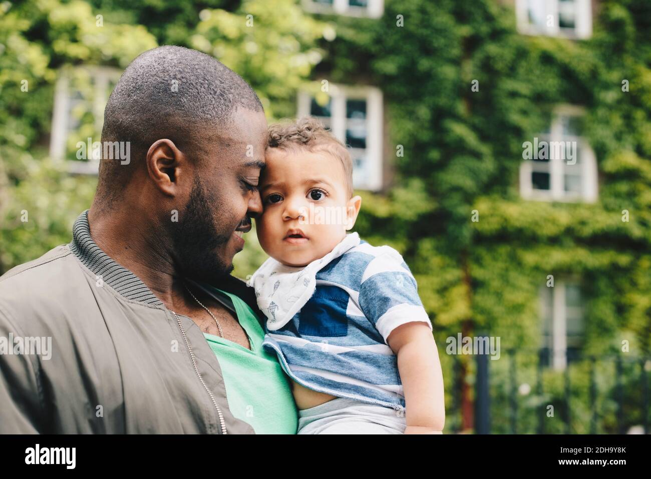 Close-up of father embracing son against building Stock Photo - Alamy