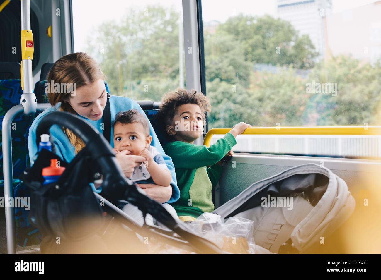 Mother sitting with sons in bus Stock Photo - Alamy