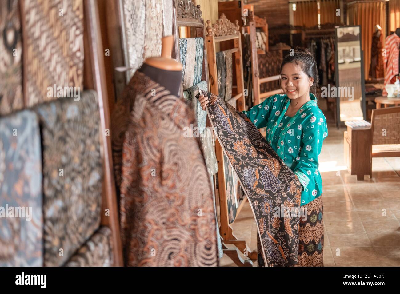 portrait of young customer service in traditional indonesian batik ...
