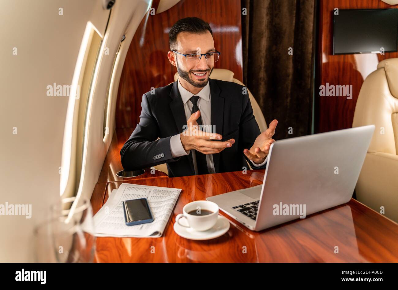 Handsome businessman wearing elegant suit flying on exclusive private ...