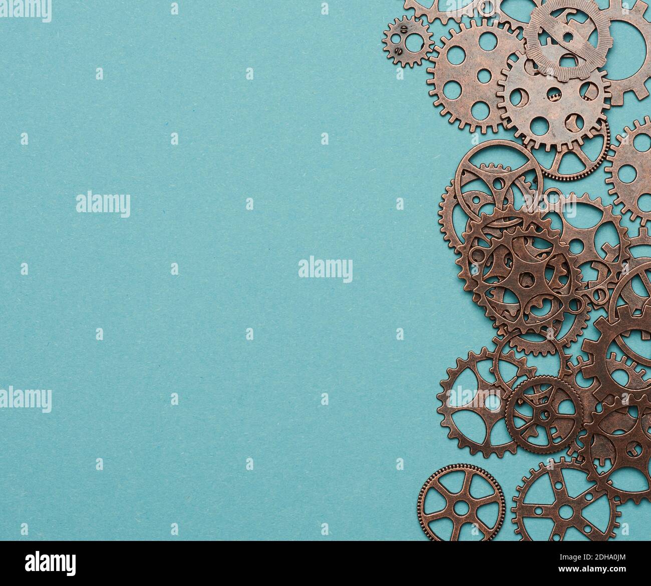 Copper various cogs on a blue background Stock Photo - Alamy