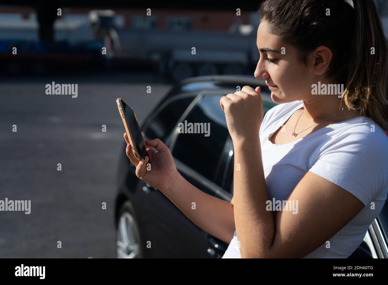 A young female using a mobile phone in the street Stock Photo - Alamy