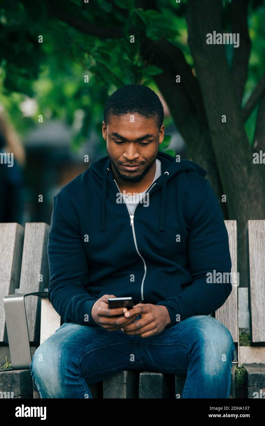 Man using smart phone bench hi-res stock photography and images - Alamy