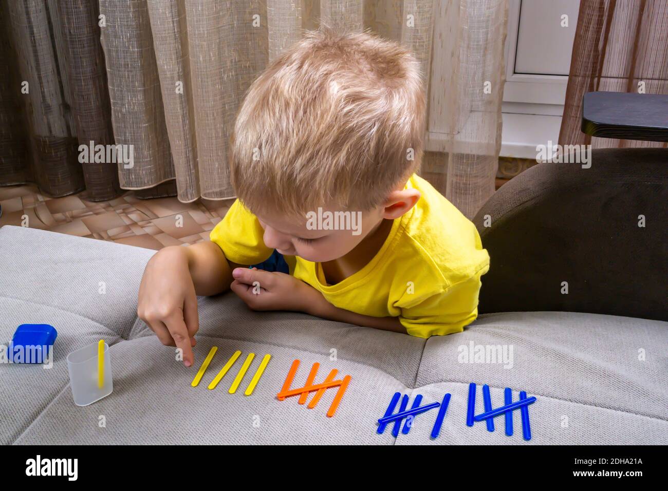 little boy learns to count with counting sticks Stock Photo - Alamy