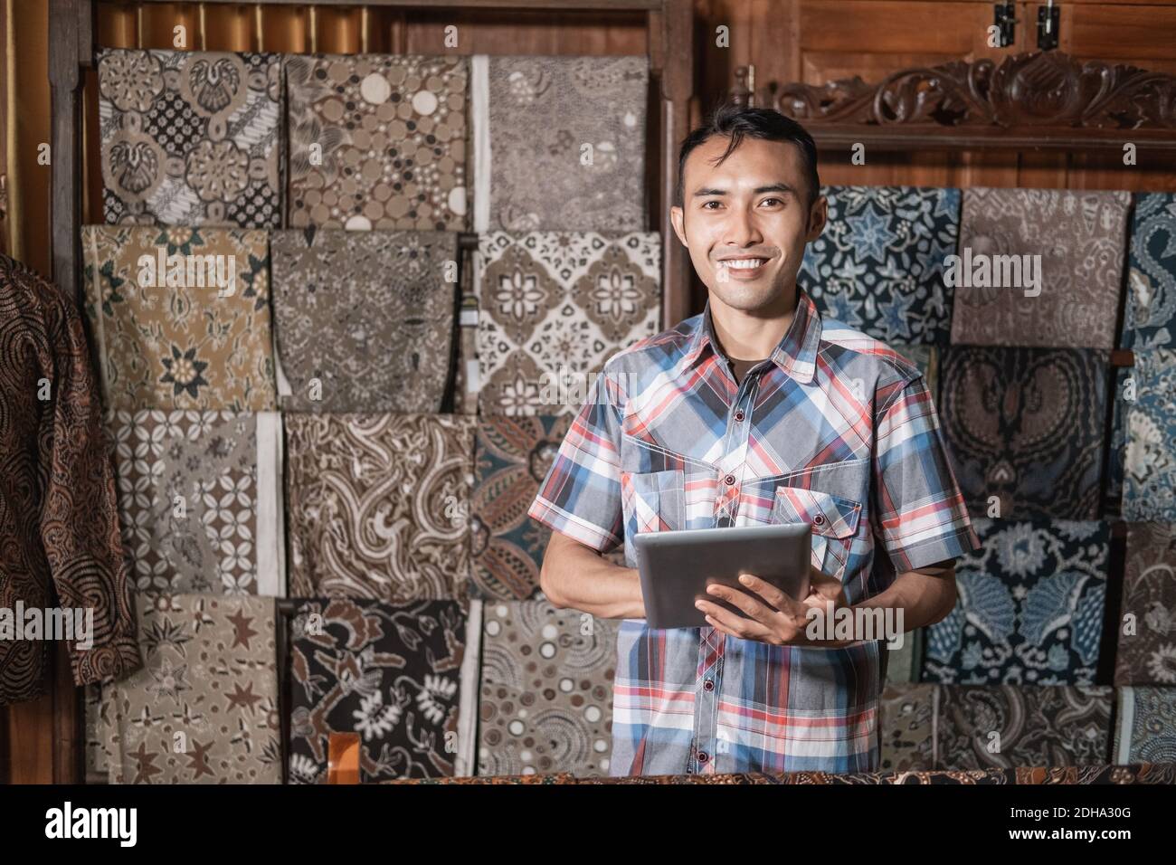 portrait of young customer service in traditional indonesian batik ...