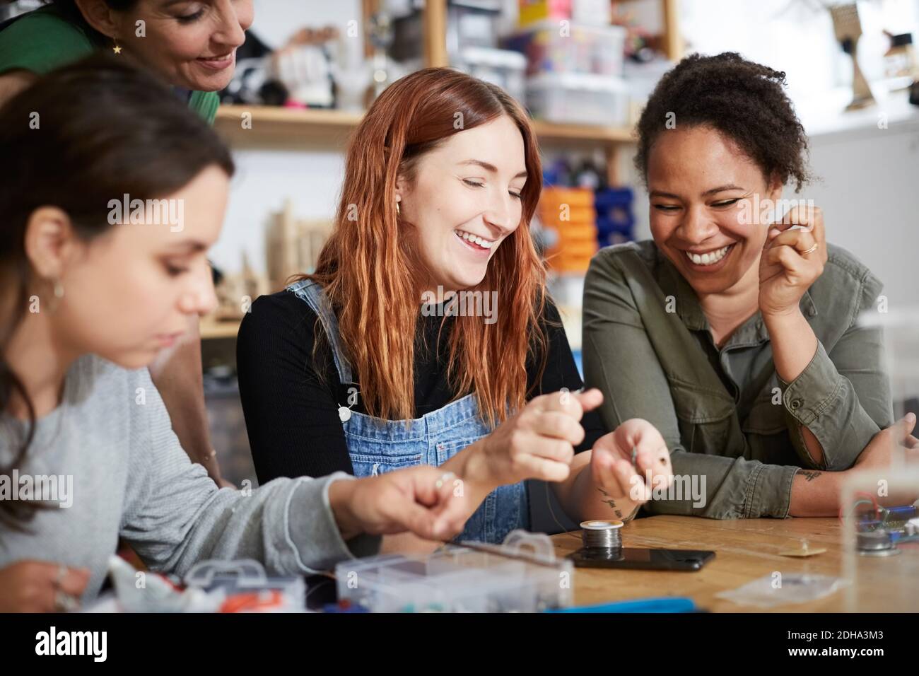 Cheerful female engineers at table in workshop Stock Photo - Alamy