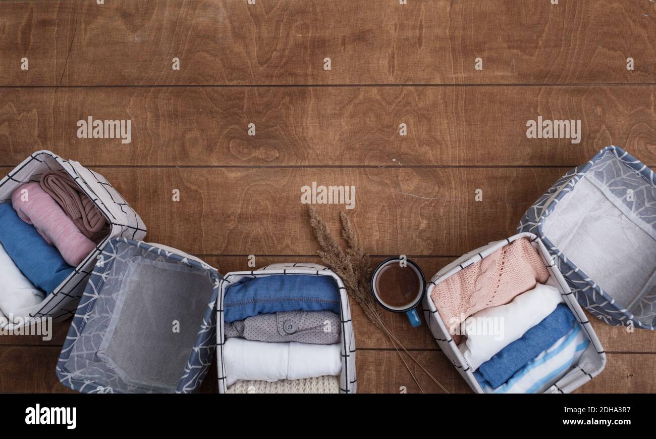 A group of organic cotton clothing laid out on a wooden background is ...