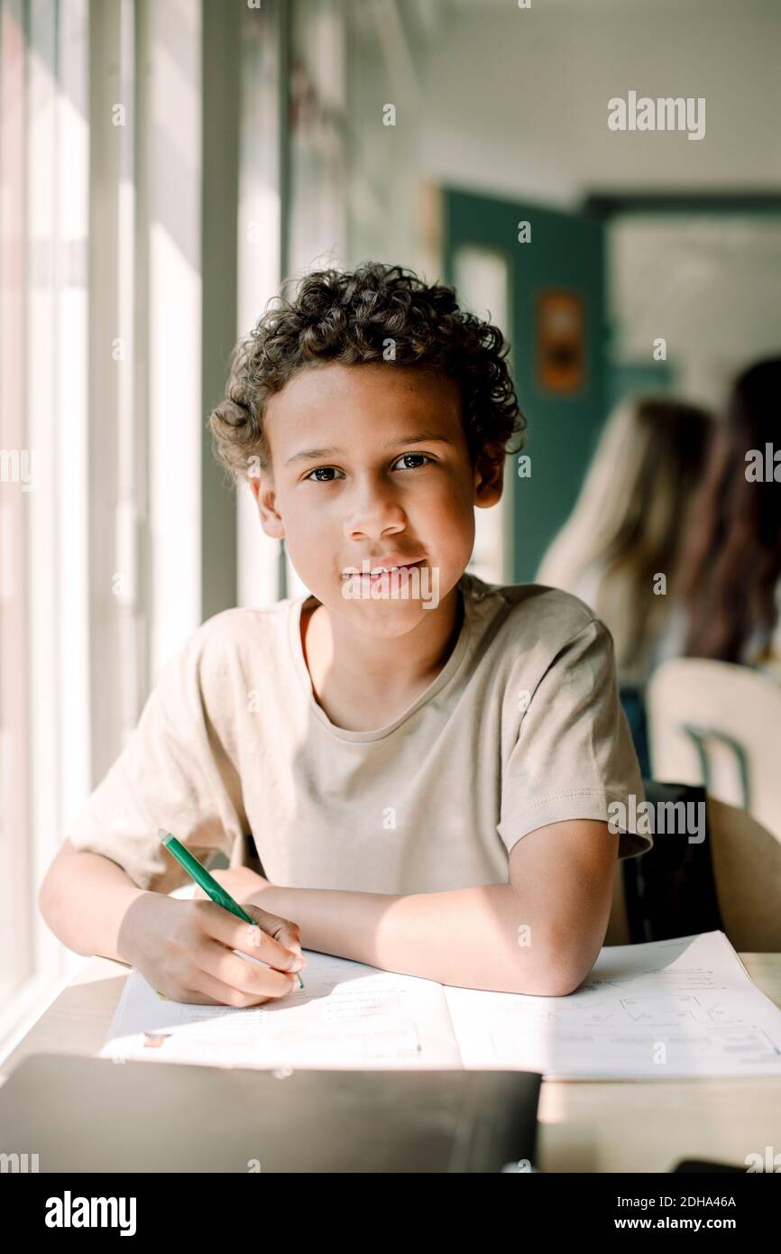 Portrait of male student studying in classroom Stock Photo - Alamy