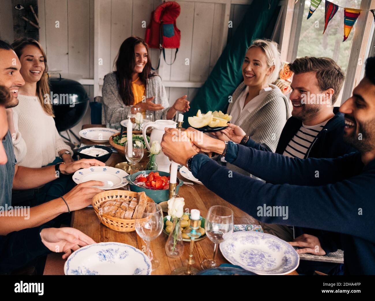 Happy man lighting candle while sitting with friends for lunch Stock ...