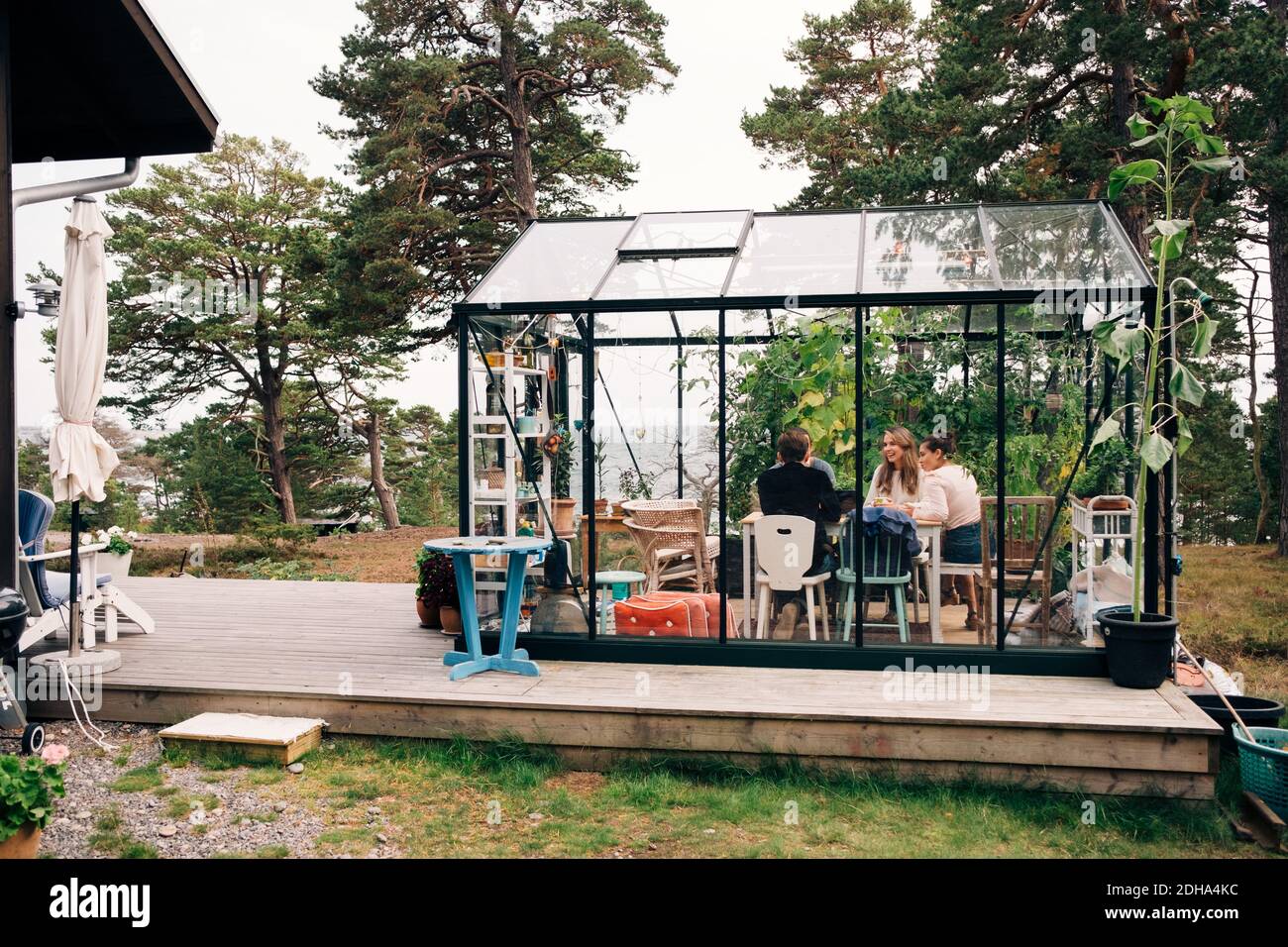 Friends sitting together in glass cabin Stock Photo - Alamy