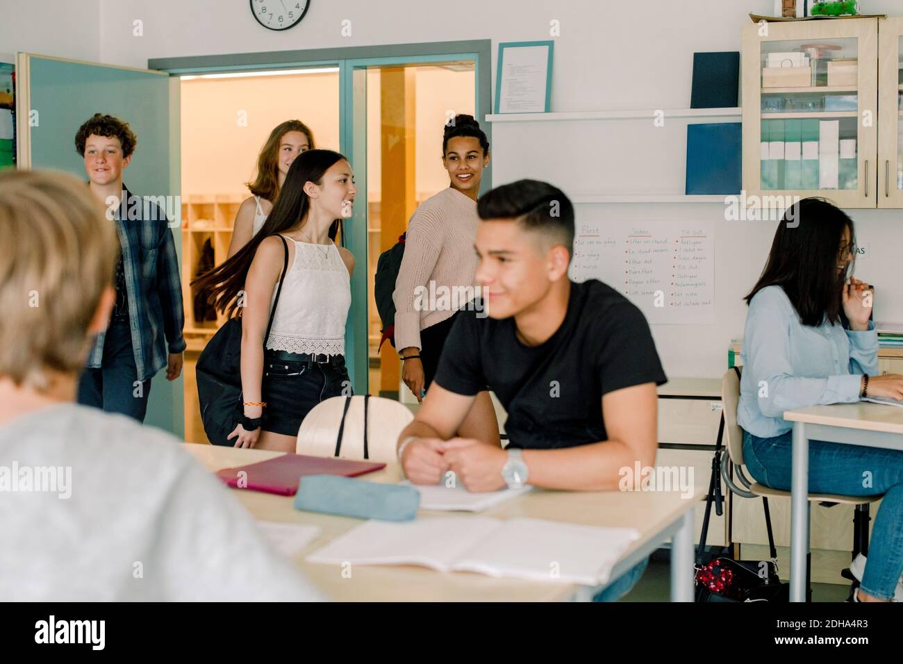 Smiling male and female students entering in classroom Stock Photo - Alamy