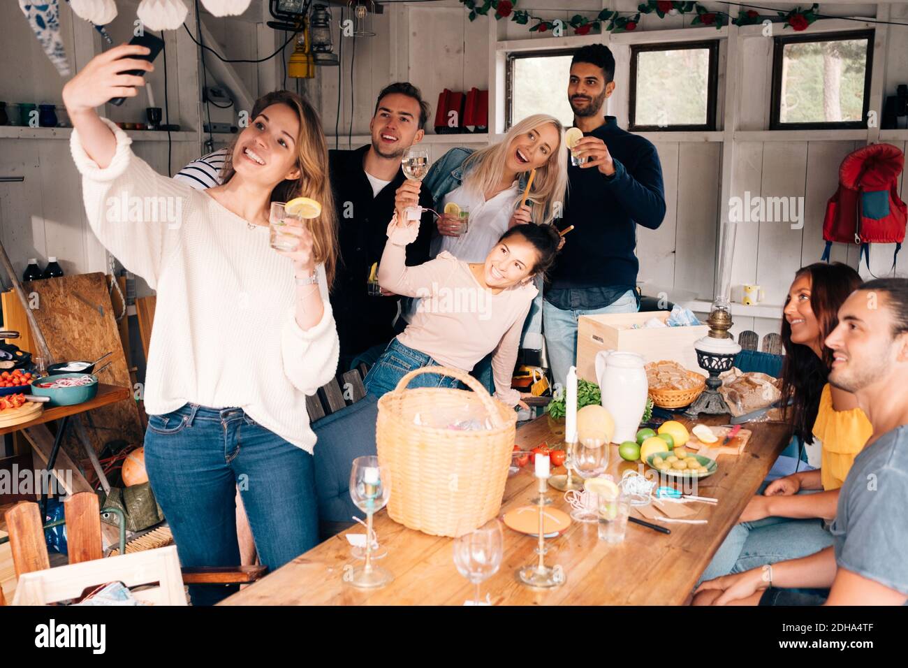 Young woman taking selfie with friends during lunch party Stock Photo ...