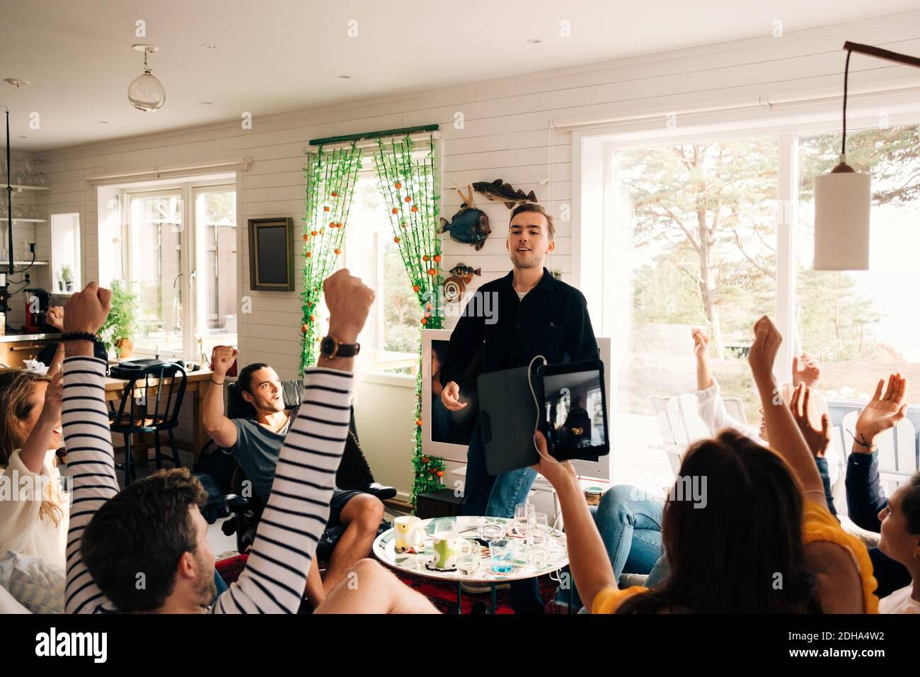 Happy friends celebrating success of man in cottage Stock Photo - Alamy