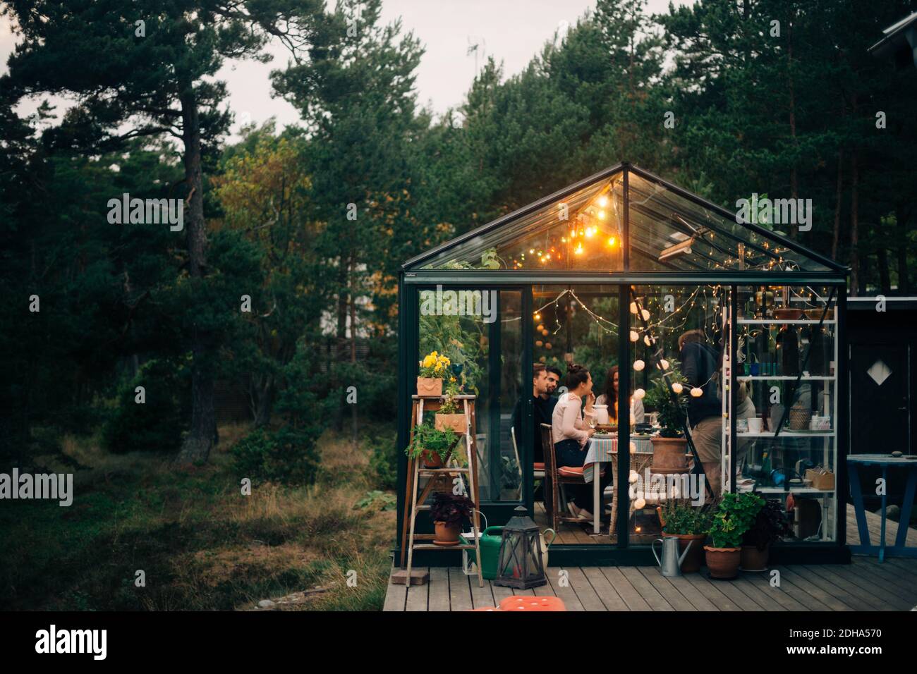 Friends having party in glass cabin during sunset Stock Photo - Alamy