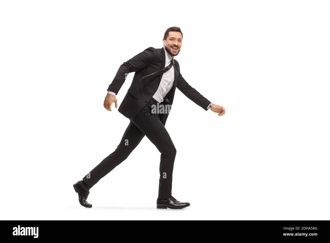 Handsome man in a black suit running and looking at camera isolated on ...