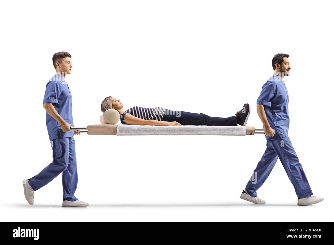 Full length profile shot of male medical workers carrying a stretcher ...