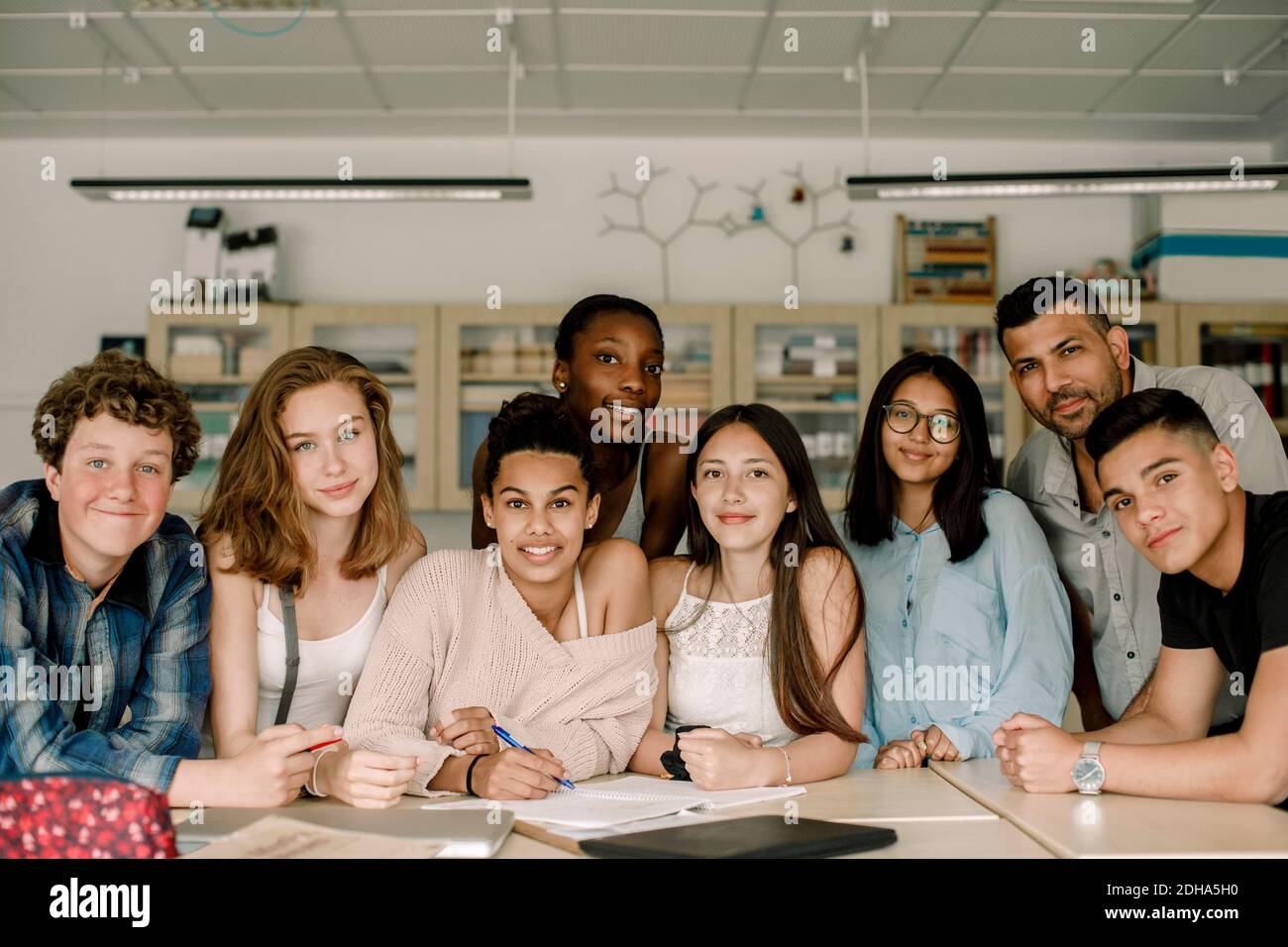 Portrait of professor with teenage students by table in classroom Stock ...