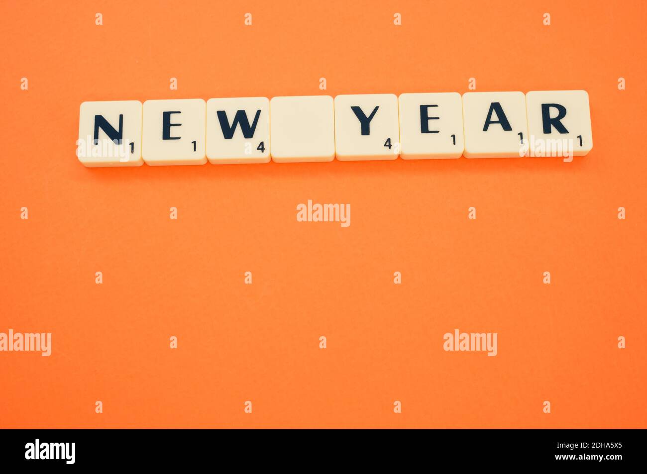 A top view of "New Year" made of white tiles on orange background for a ...