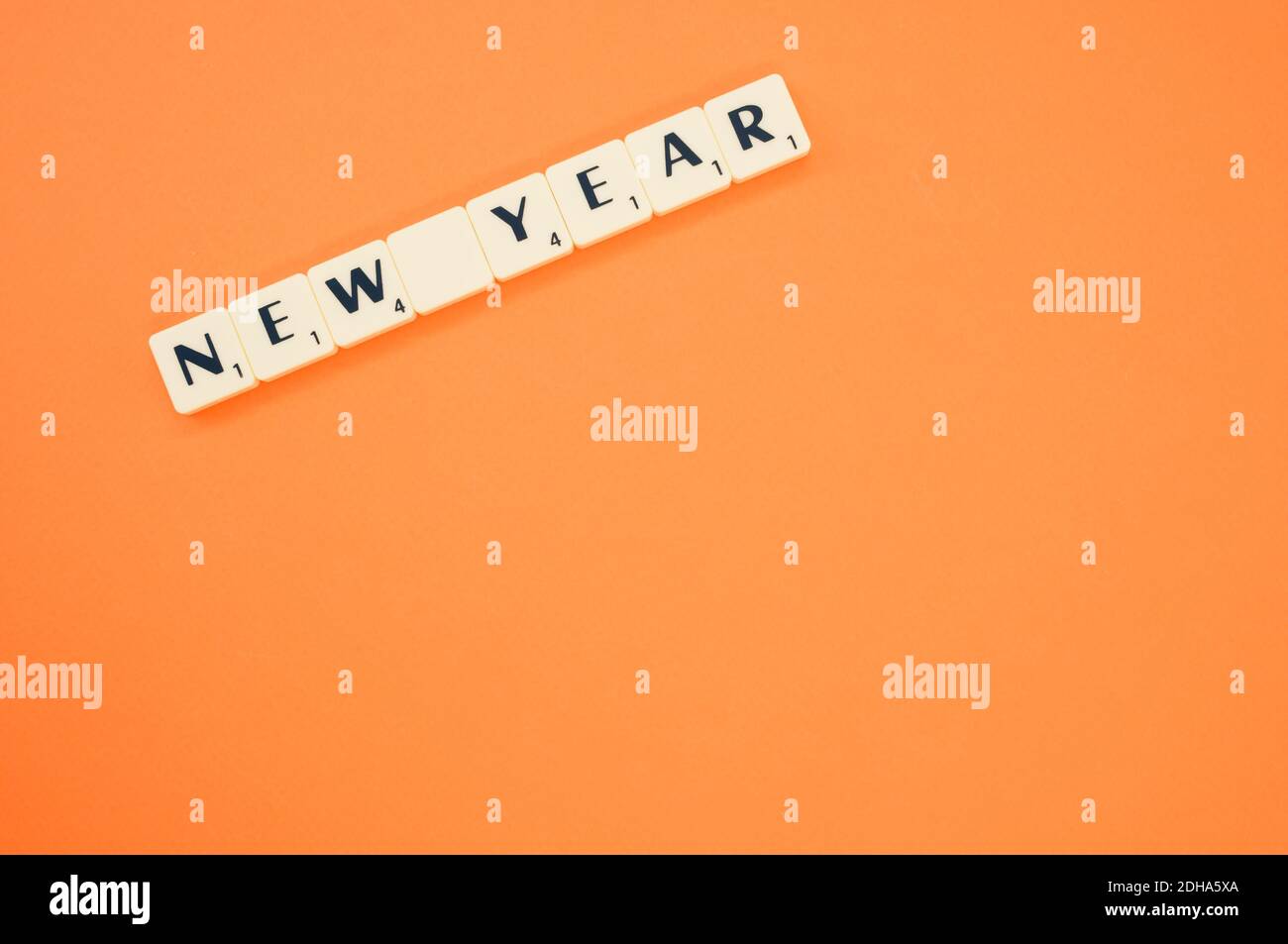 A top view of "New Year" made of white tiles on orange background for a ...