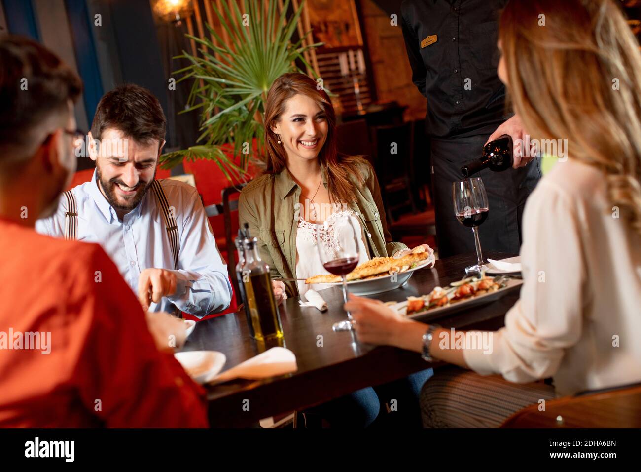 Group of young people having dinner in the restaurant Stock Photo - Alamy