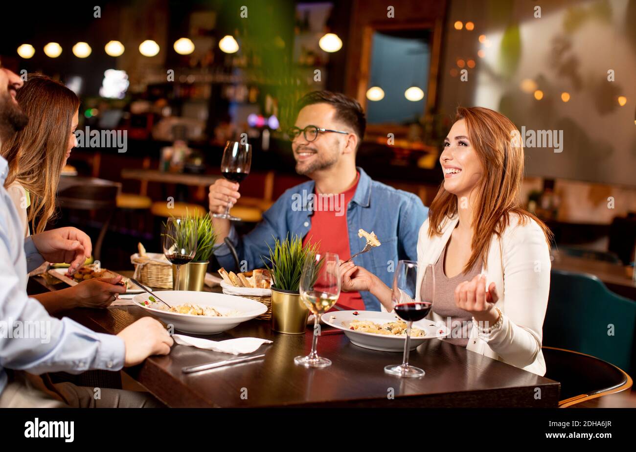 Group of young people having dinner in the restaurant Stock Photo - Alamy