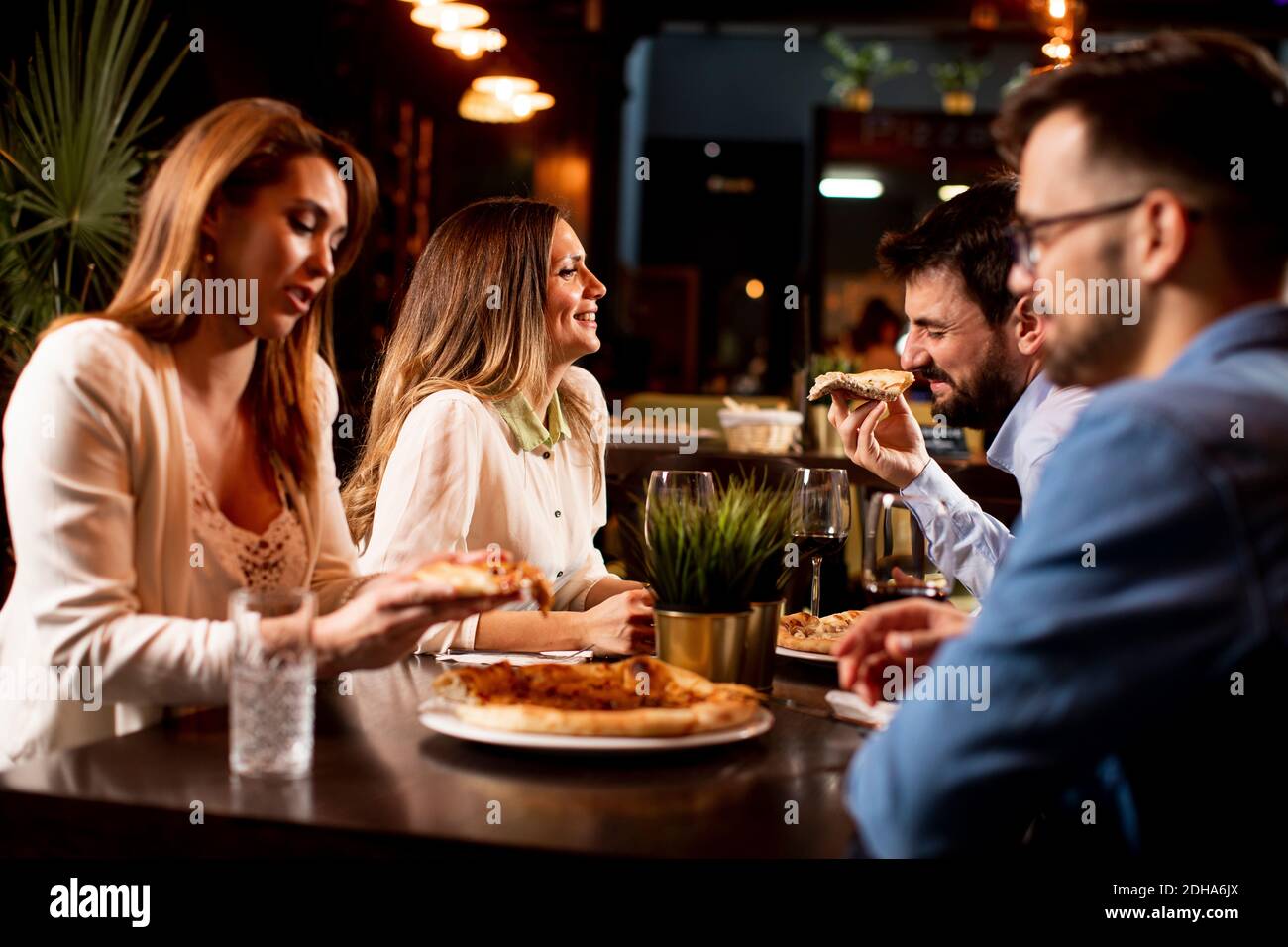 Group of young people having dinner in the restaurant Stock Photo - Alamy
