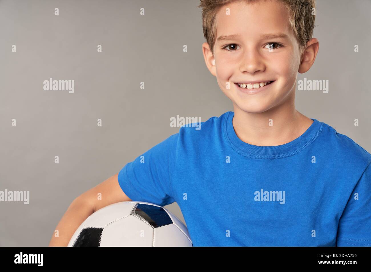 Close up of adorable male child football player looking at camera and ...