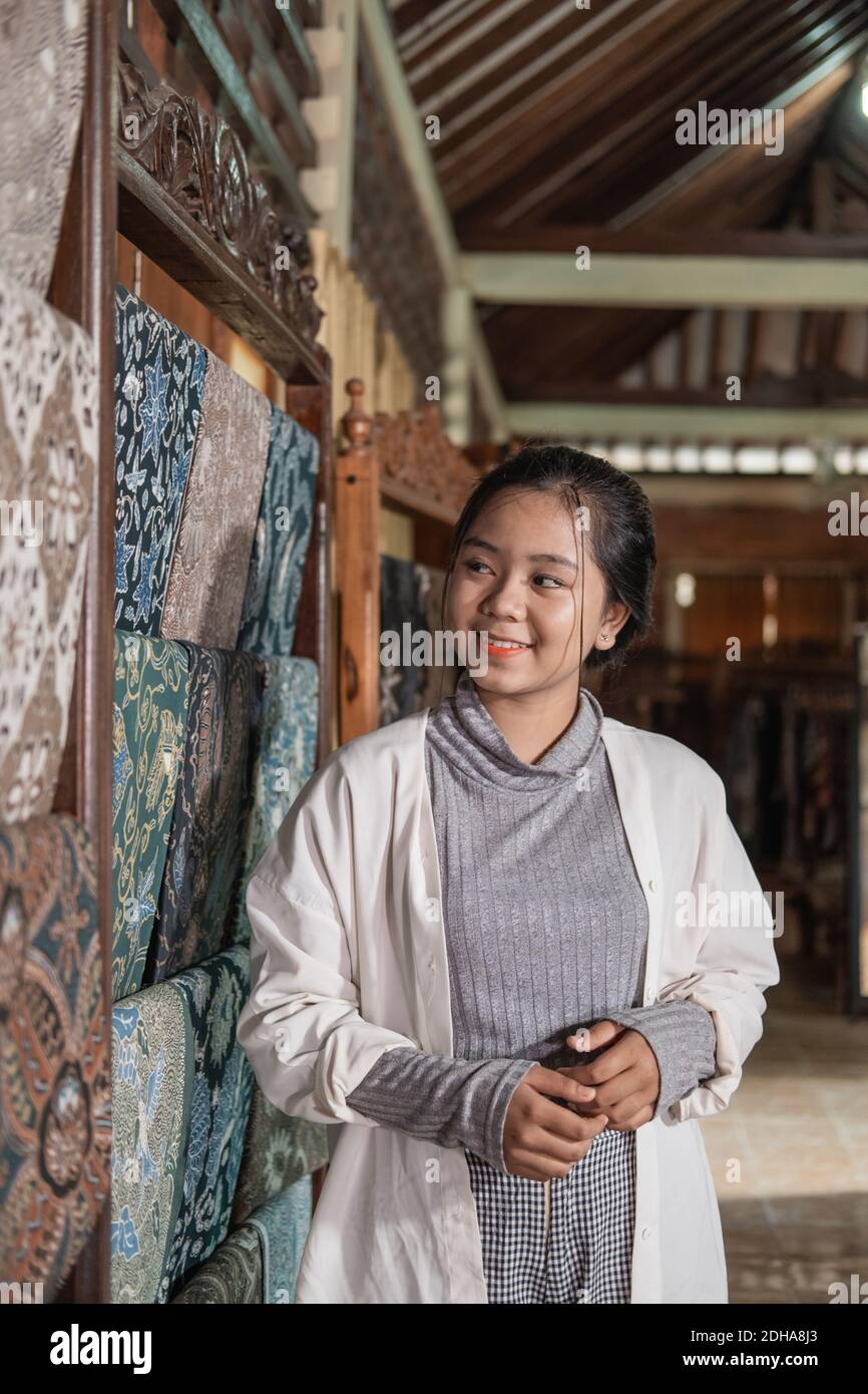 portrait of young women selling traditional batik cloth and clothes ...