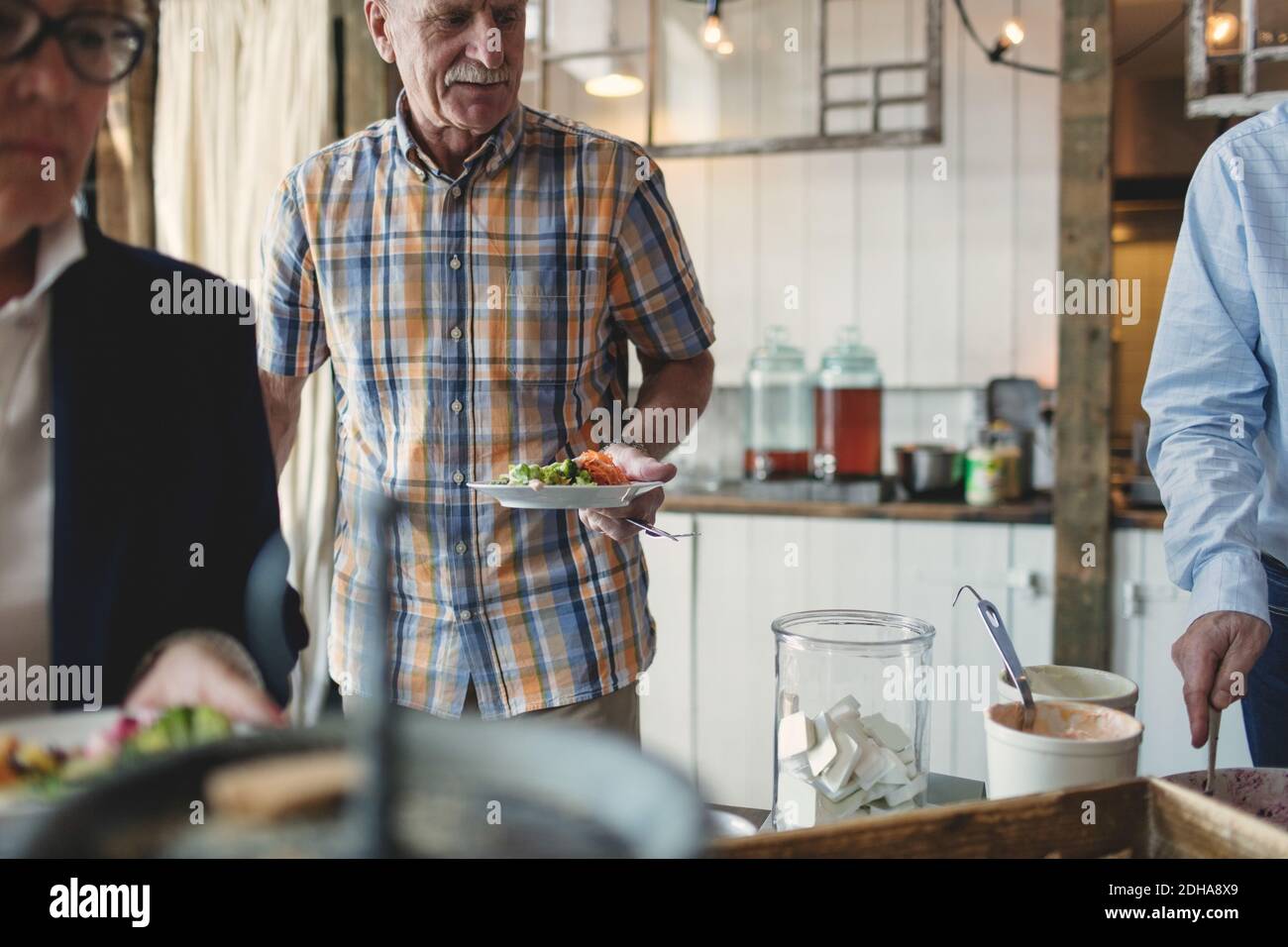 Senior man with friends at buffet counter in restaurant Stock Photo - Alamy