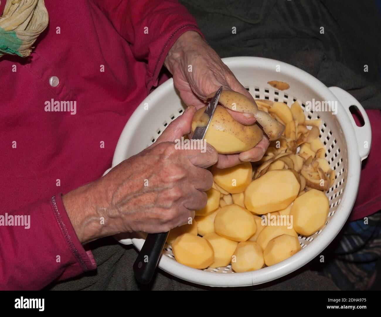 Old woman peeling potatoes hi-res stock photography and images - Alamy