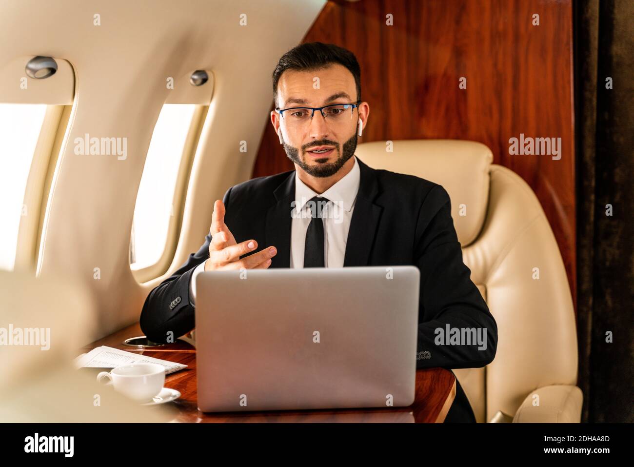 Handsome businessman wearing elegant suit flying on exclusive private ...