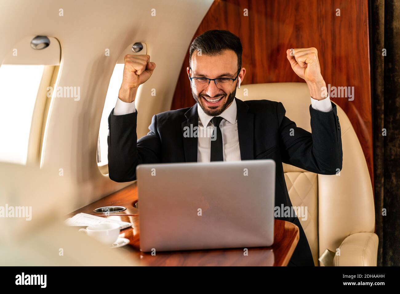 Handsome businessman wearing elegant suit flying on exclusive private ...