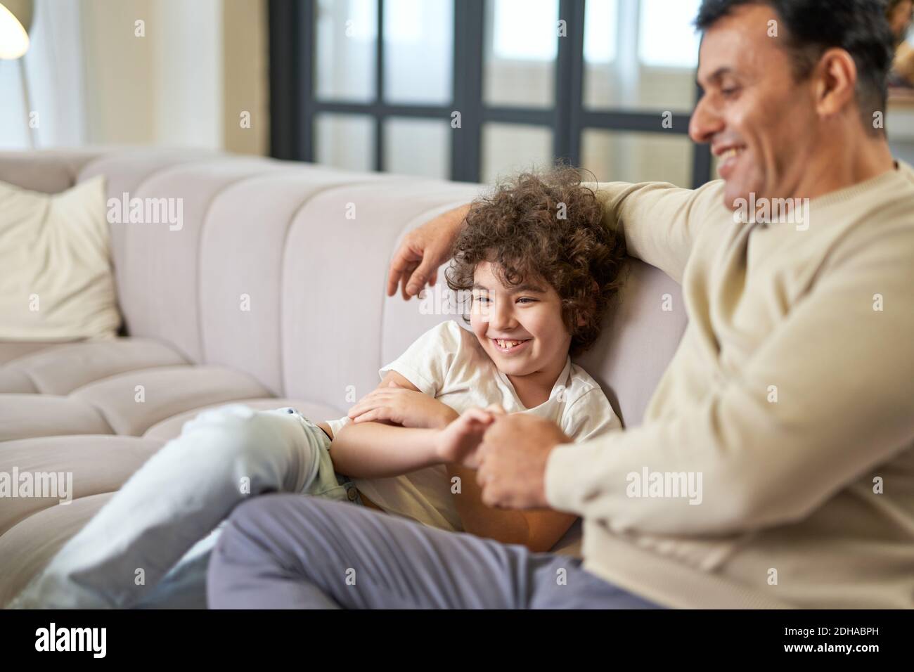 Happy latin middle aged father spending time with his son, playing with ...