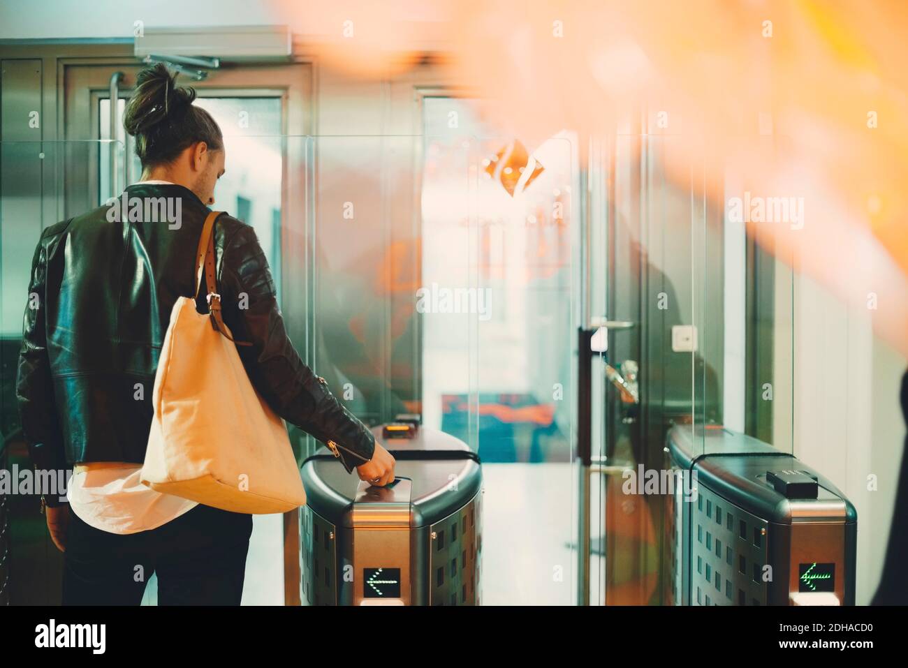 Rear view of businessman using ID card at turnstile in office Stock ...