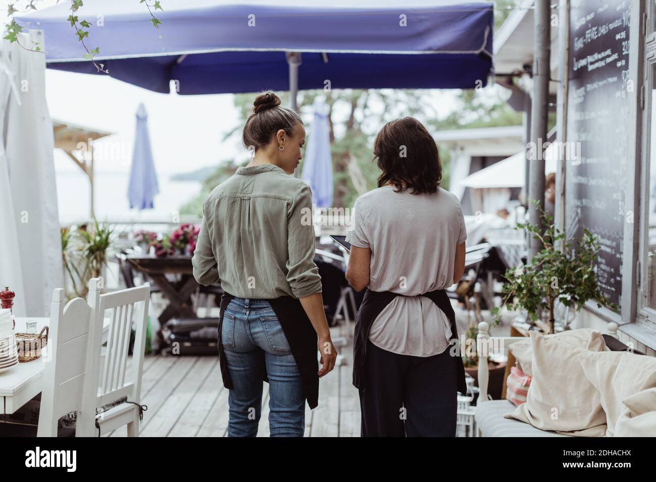 Rear view of businesswoman with coworker standing in restaurant Stock ...