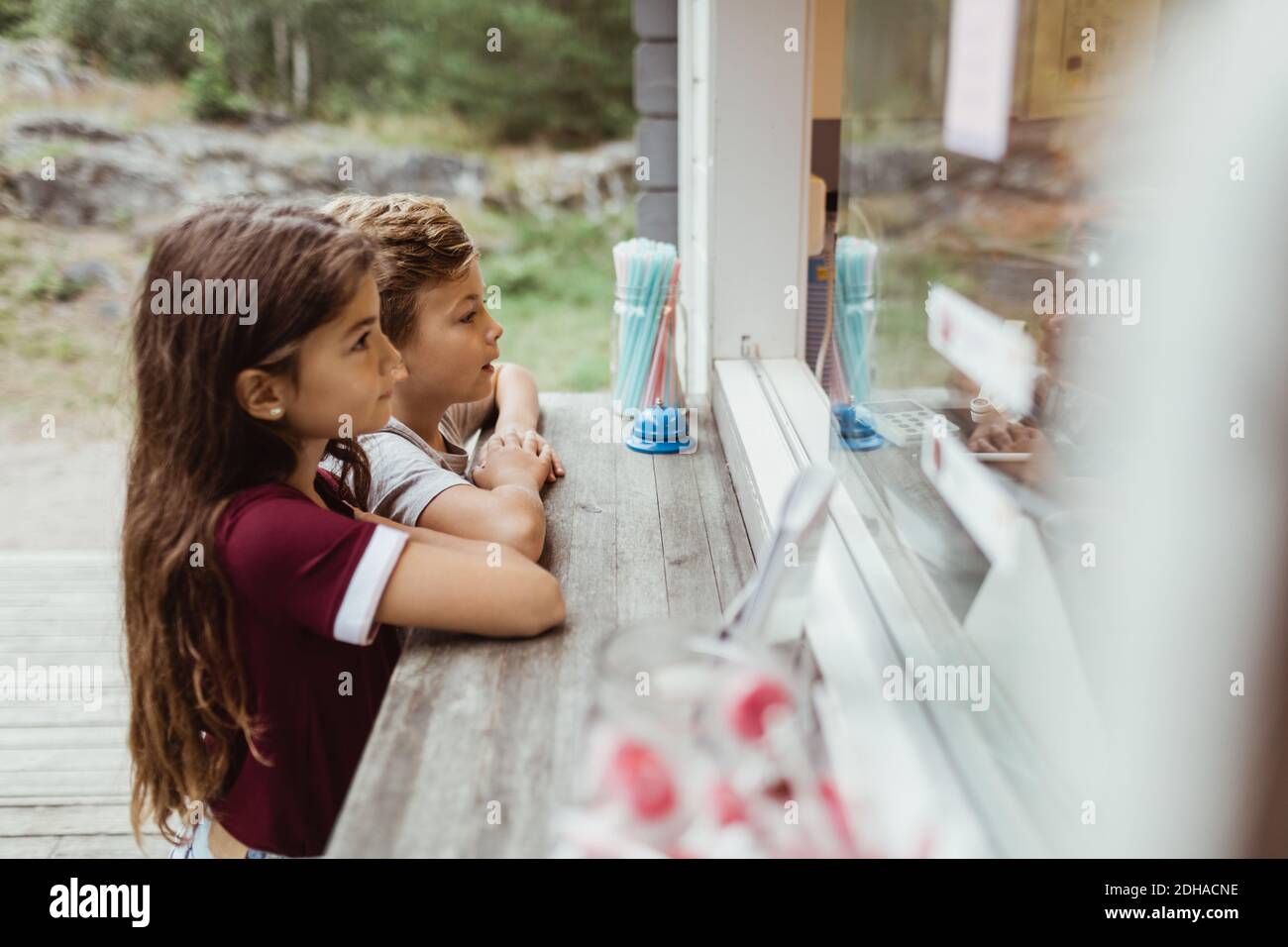 Side view of siblings standing by concession stand during vacation ...