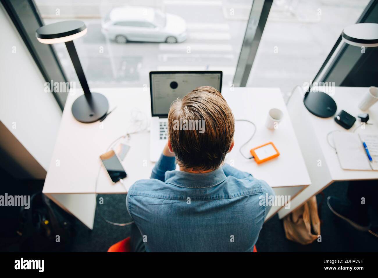 High angle rear view of businessman working at desk in office Stock ...