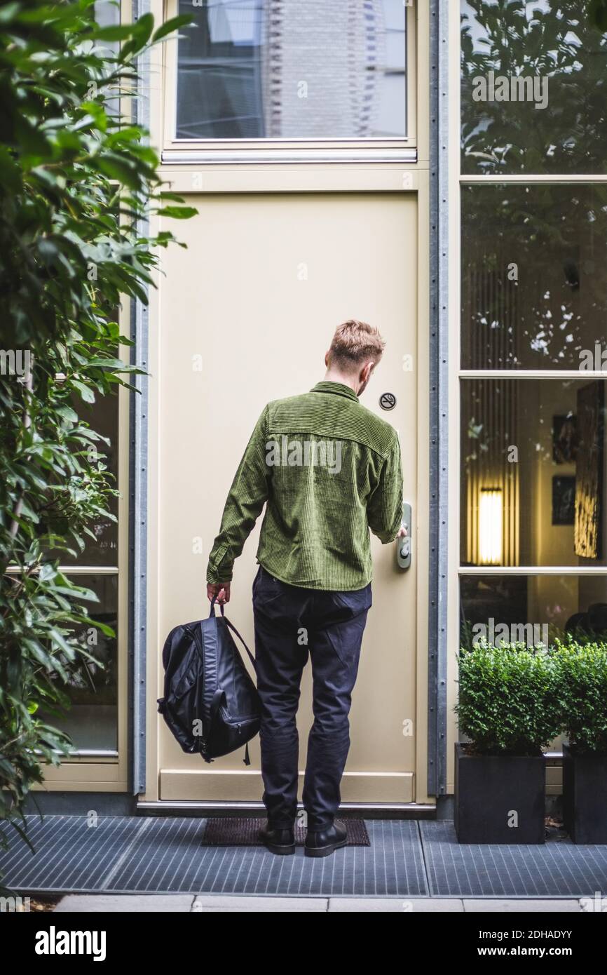 Male entrepreneur unlocking door Stock Photo - Alamy