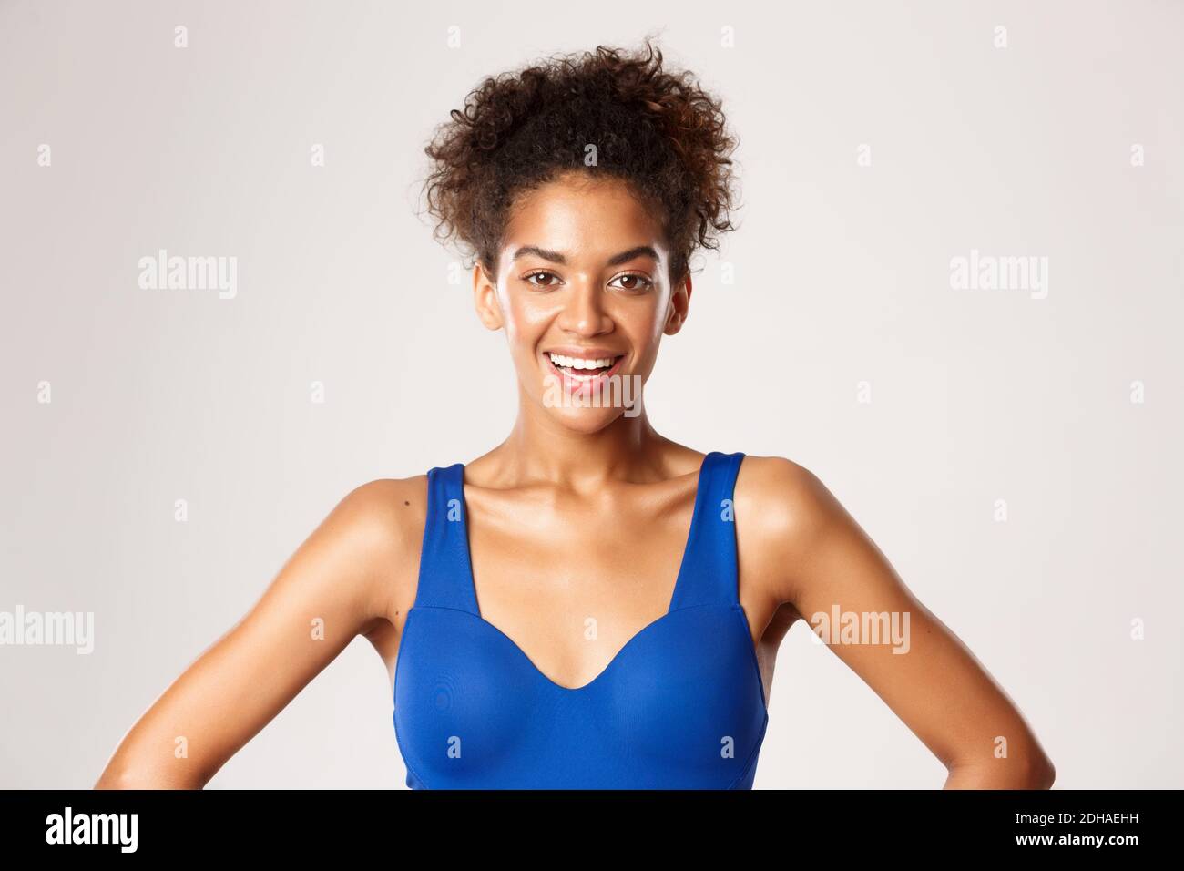 Close-up of attractive healthy woman in blue sports bra, smiling at ...