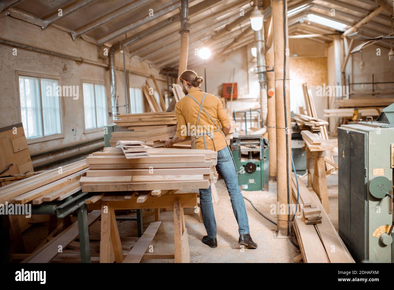 Carpenter choosing pine planks in a carpentry workshop warehouse ...