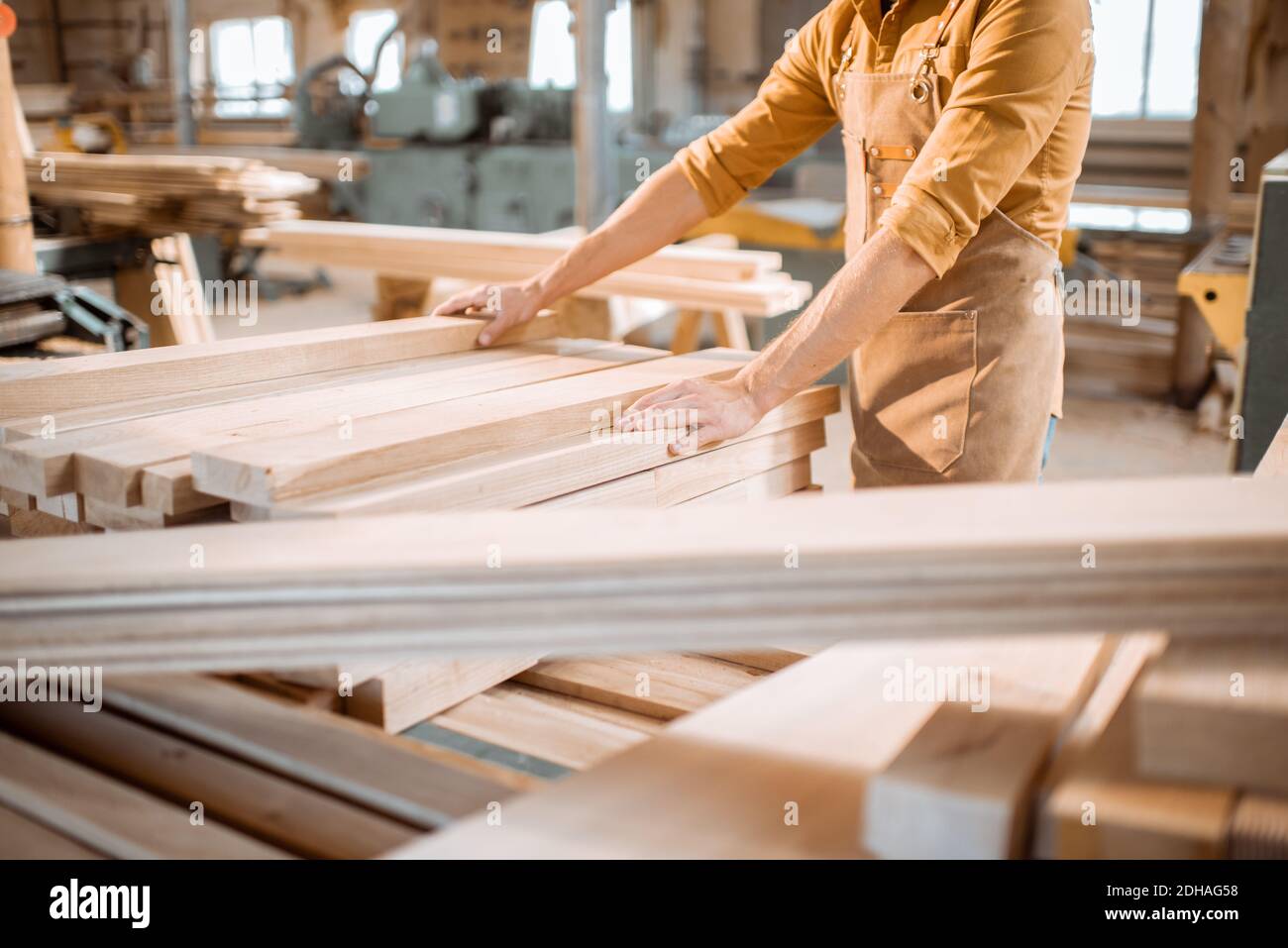 Carpenter choosing pine planks in a carpentry workshop warehouse ...