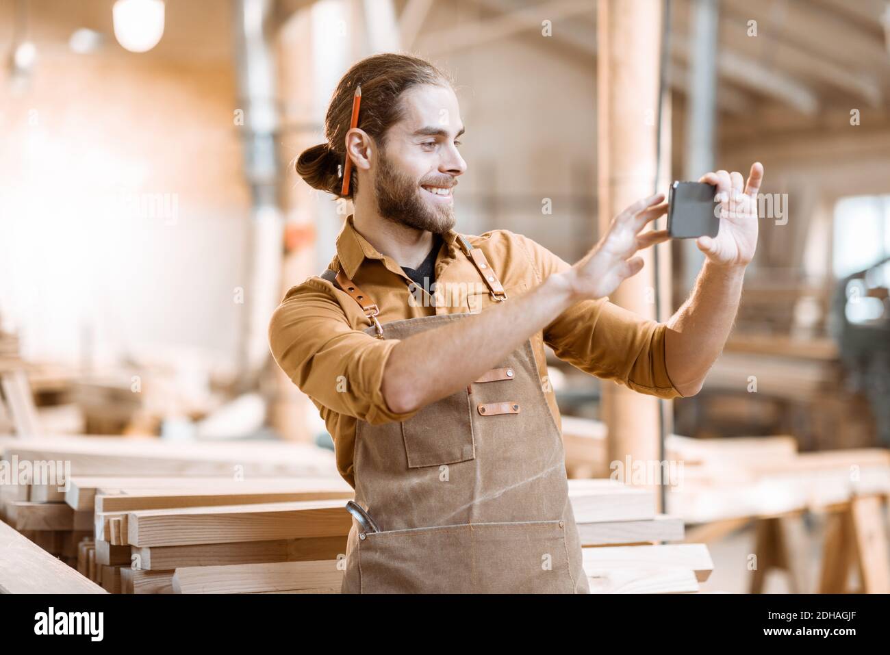 Handsome carpenter talking on smart phone or using phone to design some ...