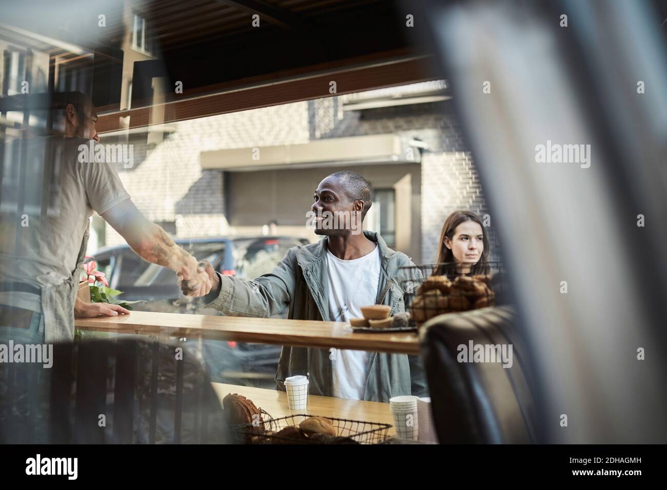 Male customer and salesman shaking hands at concession stand Stock ...