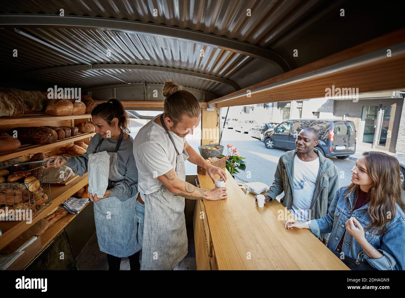 Male and female owners packing food and drink for customers at ...