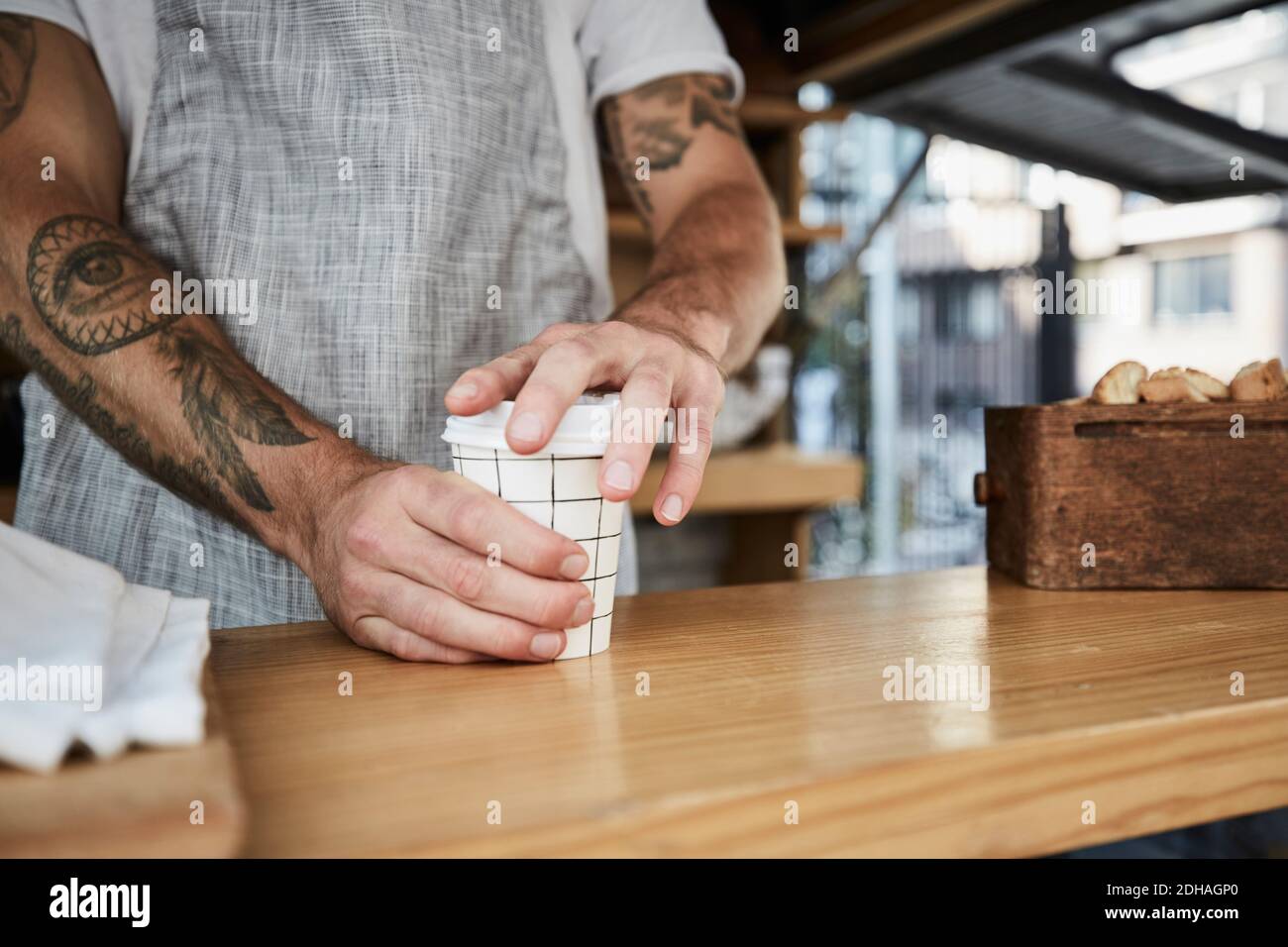 Midsection of salesman packing disposable coffee cup in food truck ...