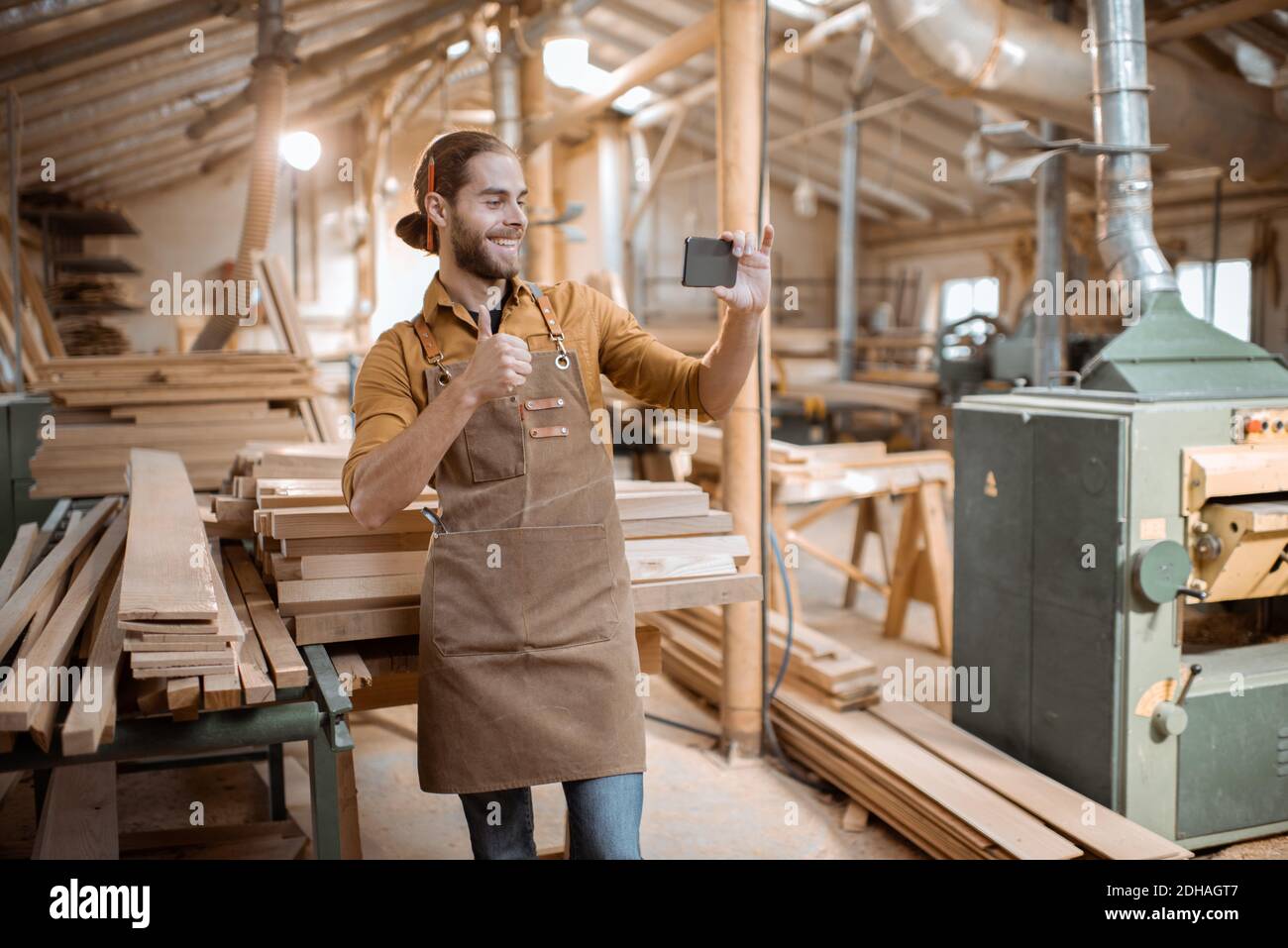 Handsome carpenter talking on smart phone or using phone to design some ...
