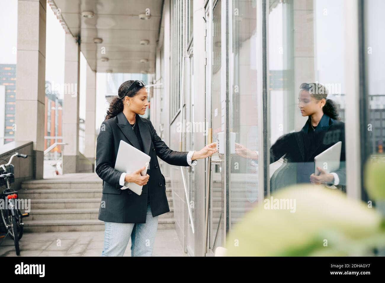Businesswoman putting keycode to open office door Stock Photo - Alamy